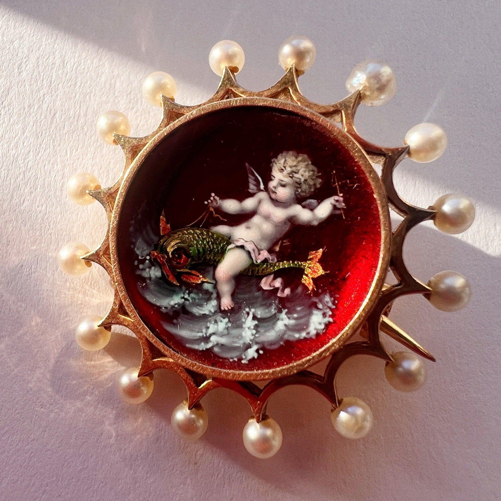Victorian era 18K gold pearl enamel cupid riding a dolphin brooch